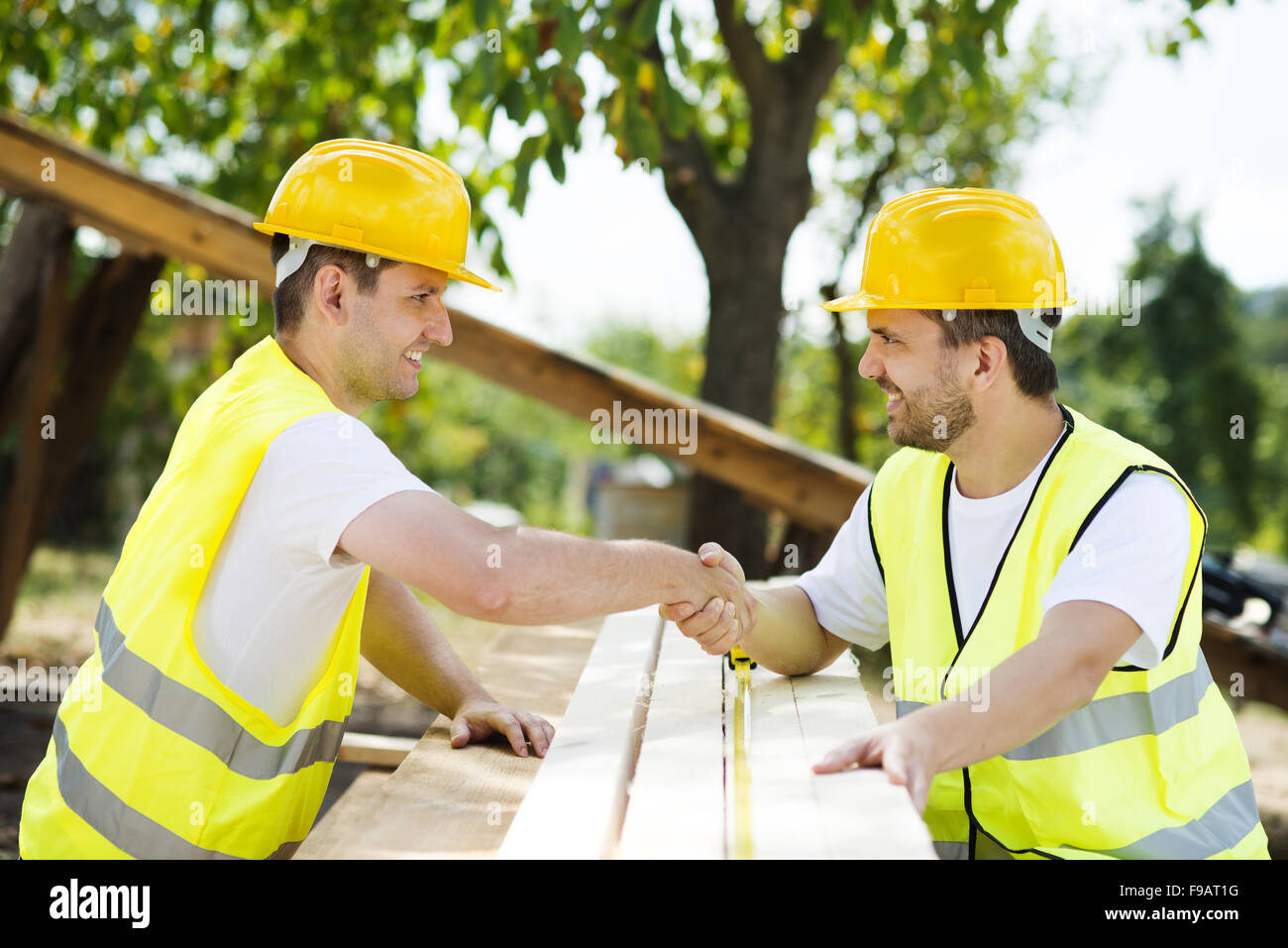 Construction workers collaborating on new house building Stock Photo ...