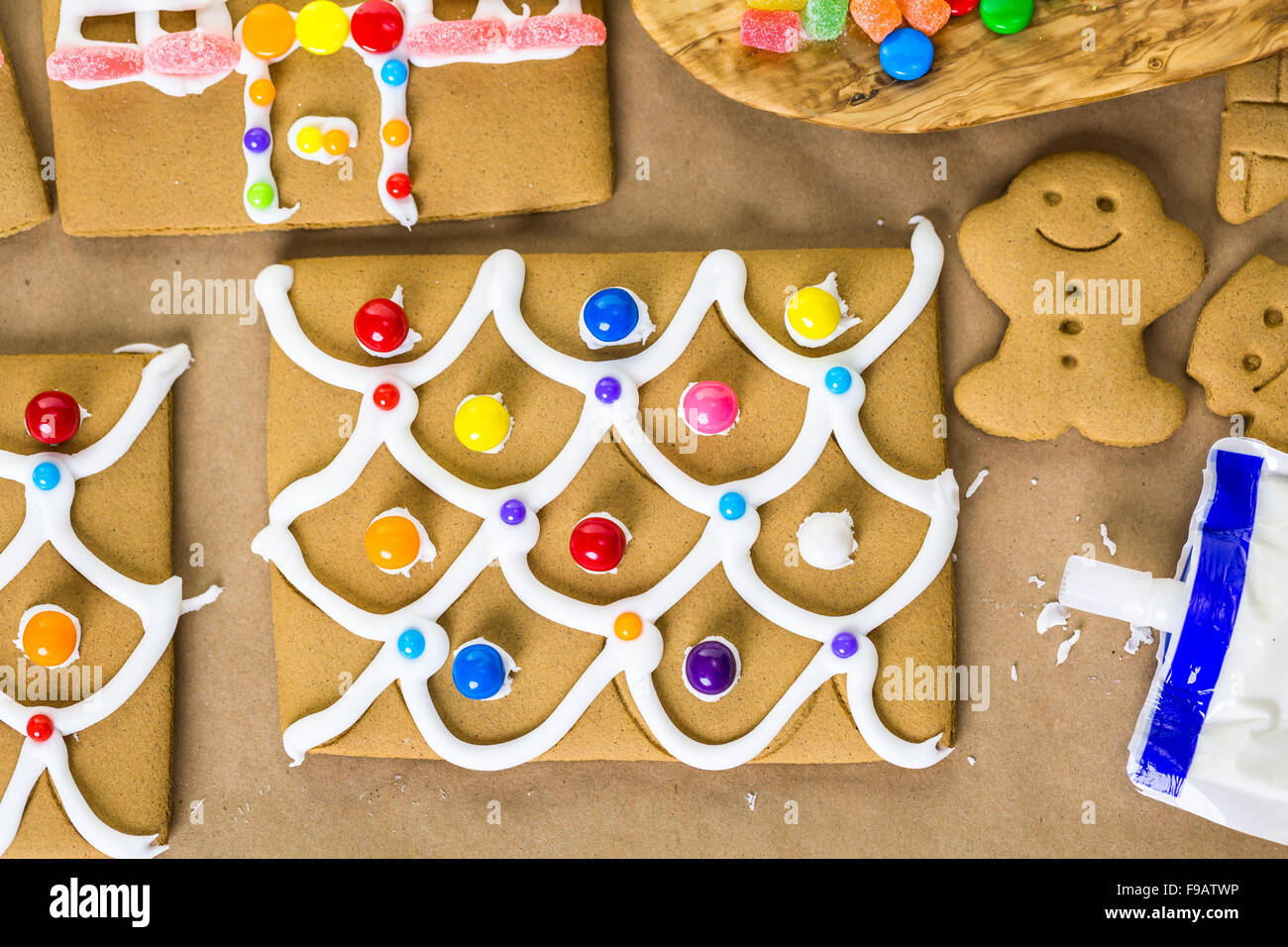 Decorating gingerbread house with royal icing and colorful candies ...