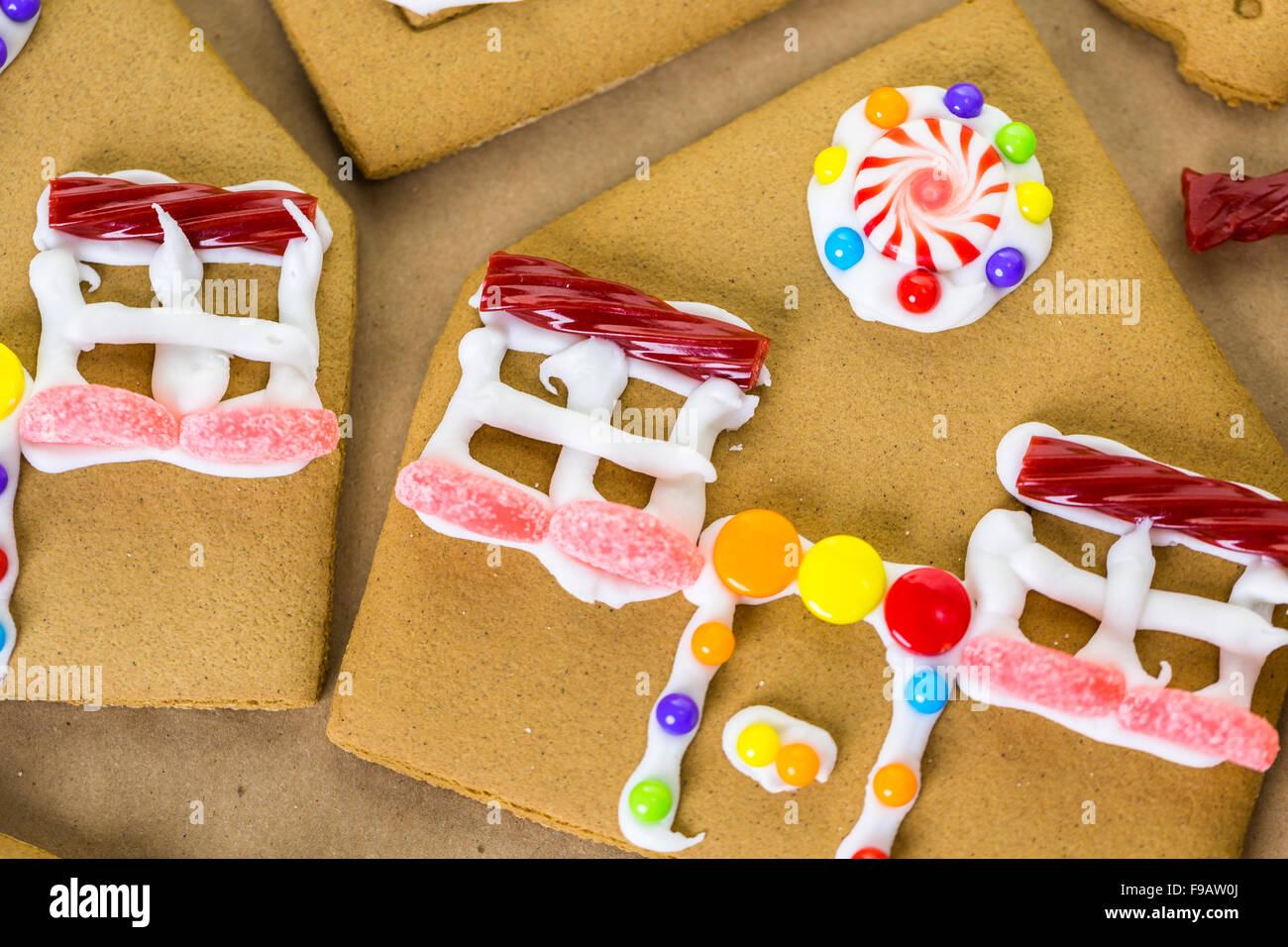Decorating gingerbread house with royal icing and colorful candies ...
