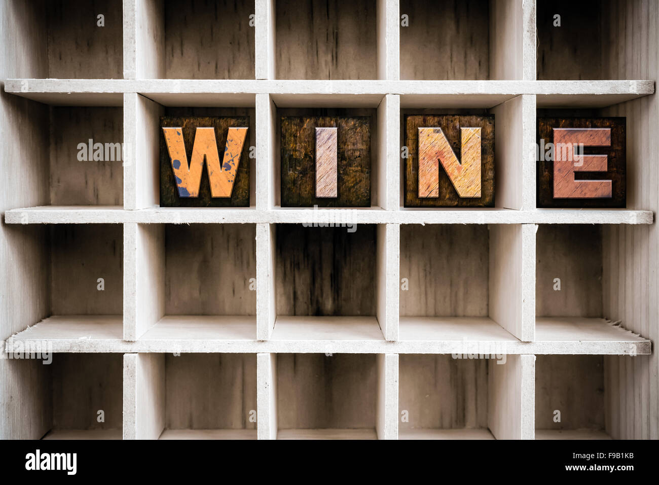 The word "WINE" written in vintage ink stained wooden letterpress type ...