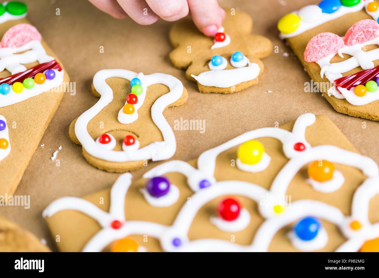 Decorating gingerbread house with royal icing and colorful candies ...
