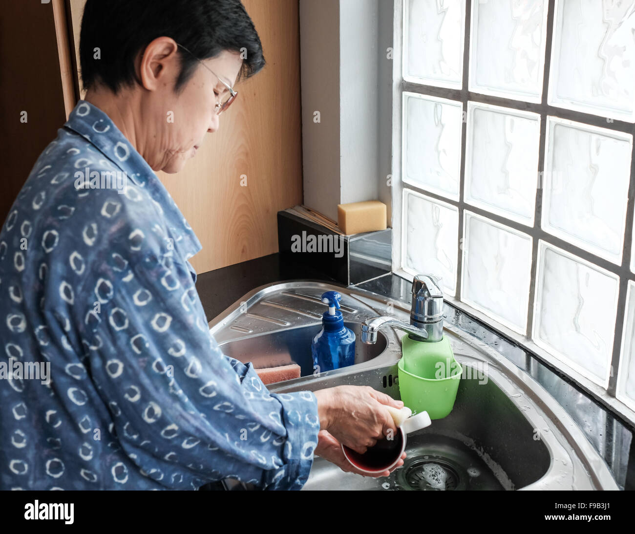 Thai woman cleaning cups at the kitchen sink Stock Photo - Alamy