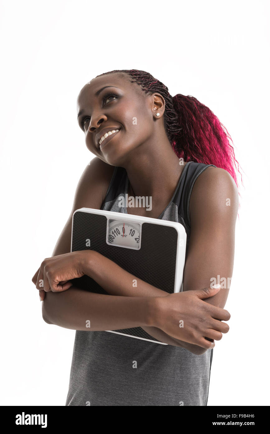 Beautiful young healthy african woman holding scales. Diet. Isolated on ...