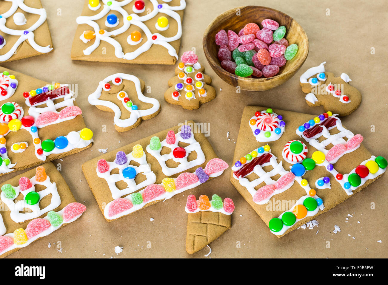 Decorating gingerbread house with royal icing and colorful candies ...