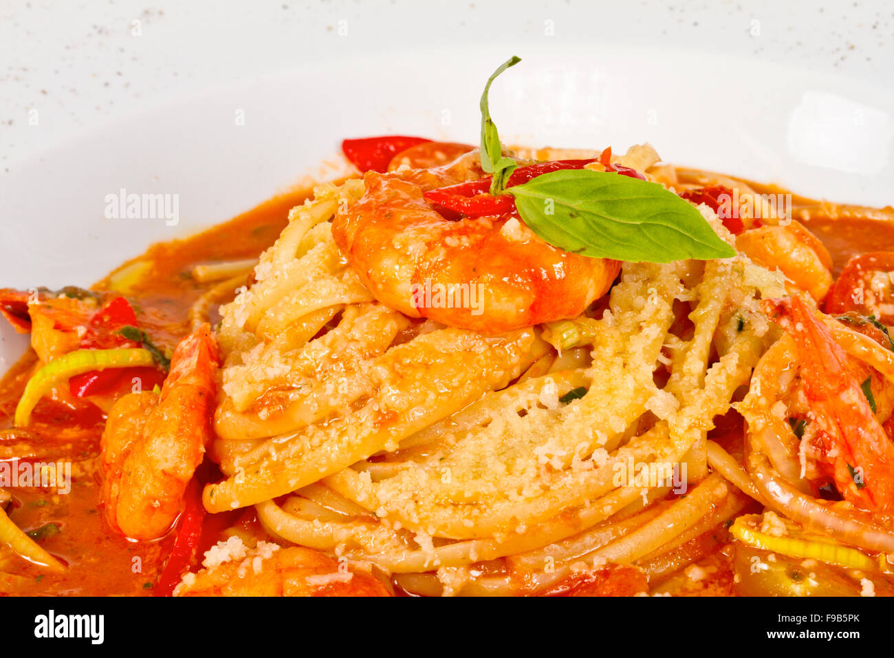 A plate of linguini with sauteed shrimp, tomato, chili and olive oil ...