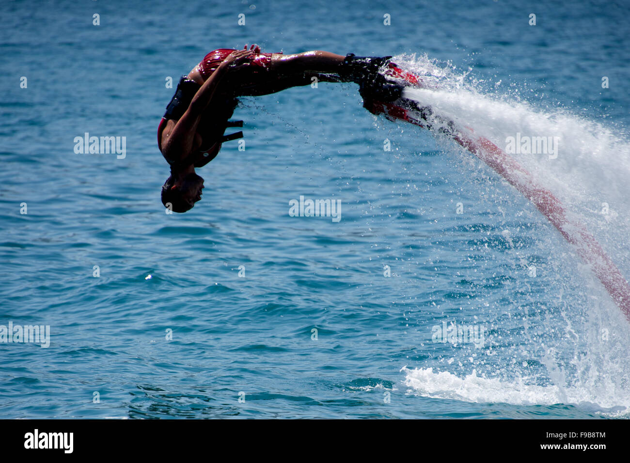 Flyboarder in red propelled by water jet Stock Photo - Alamy