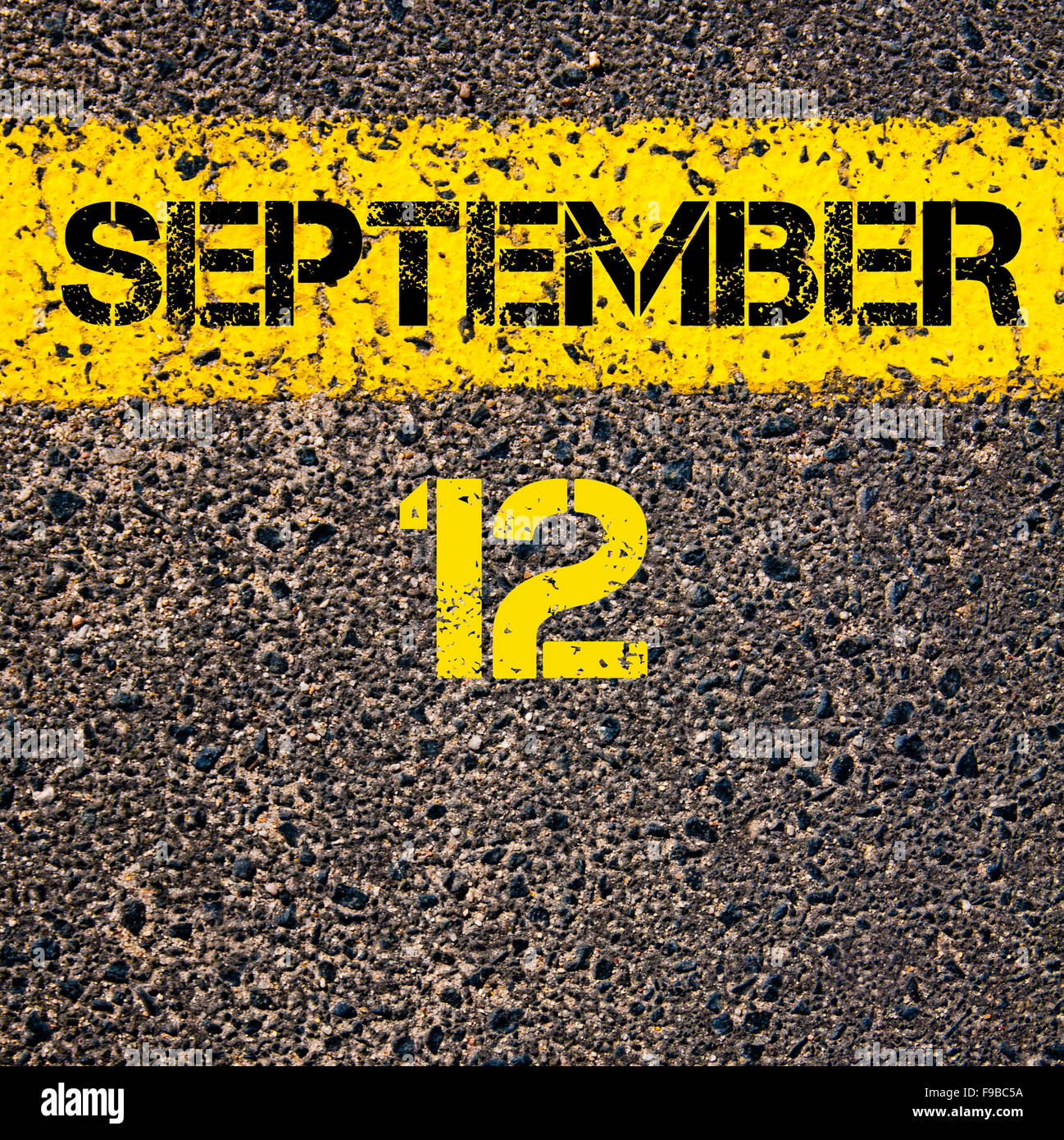 12 September calendar day written over road marking yellow paint line ...