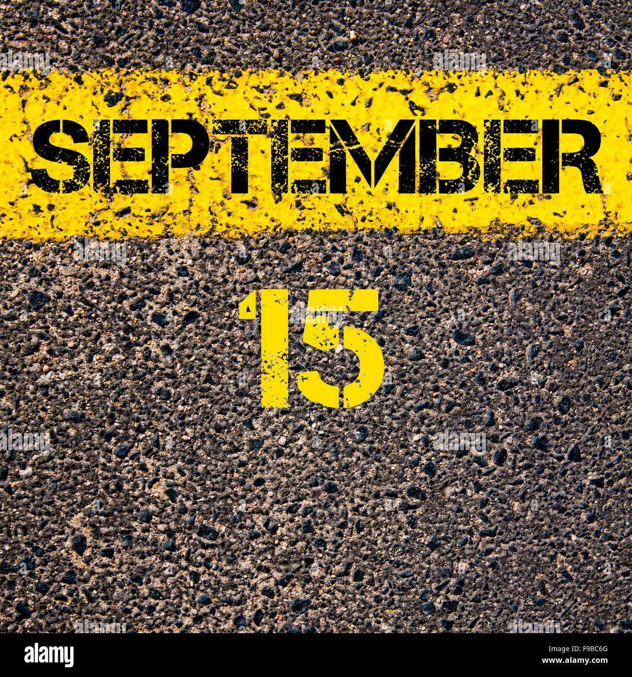 15 September calendar day written over road marking yellow paint line ...