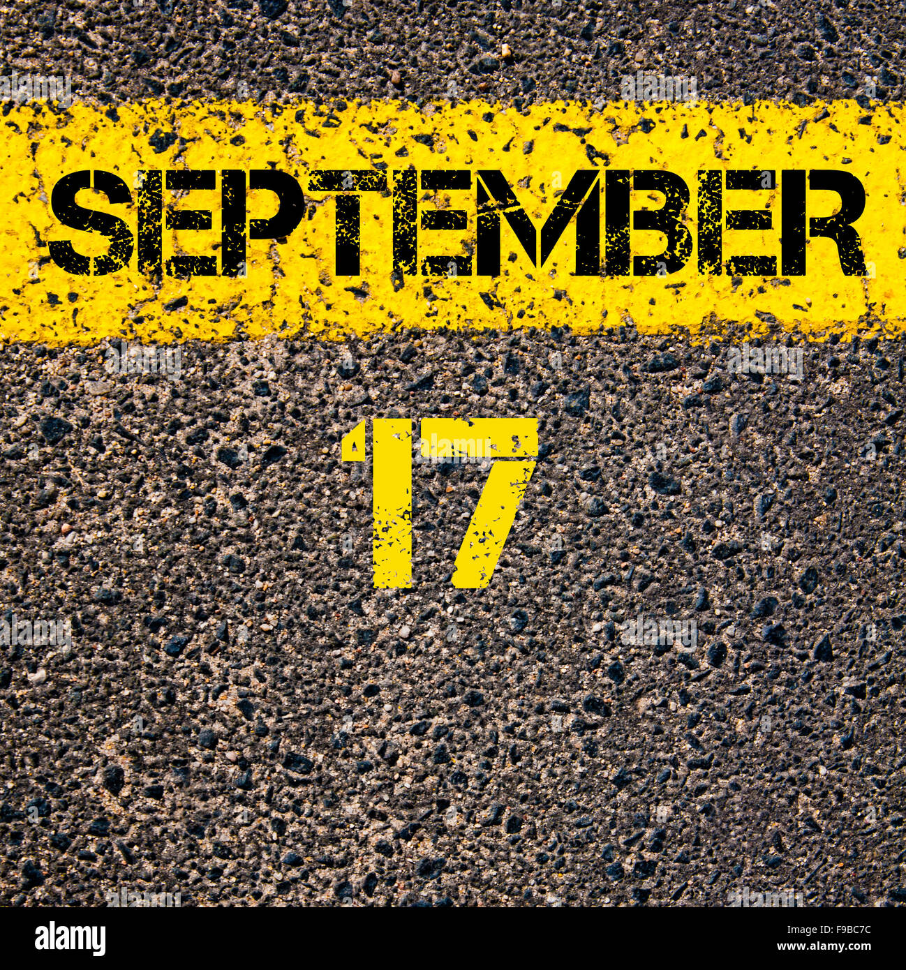 17 September calendar day written over road marking yellow paint line ...