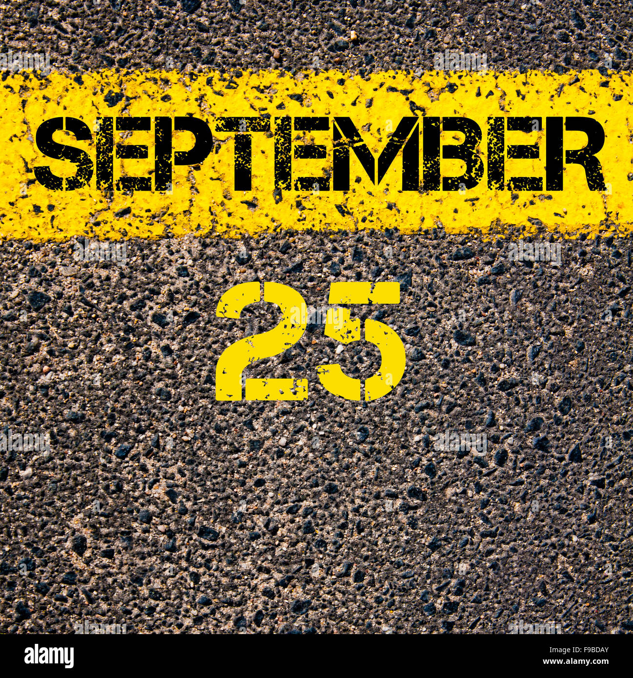 25 September calendar day written over road marking yellow paint line ...