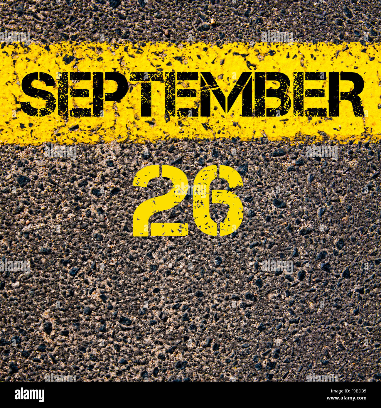 26 September calendar day written over road marking yellow paint line ...