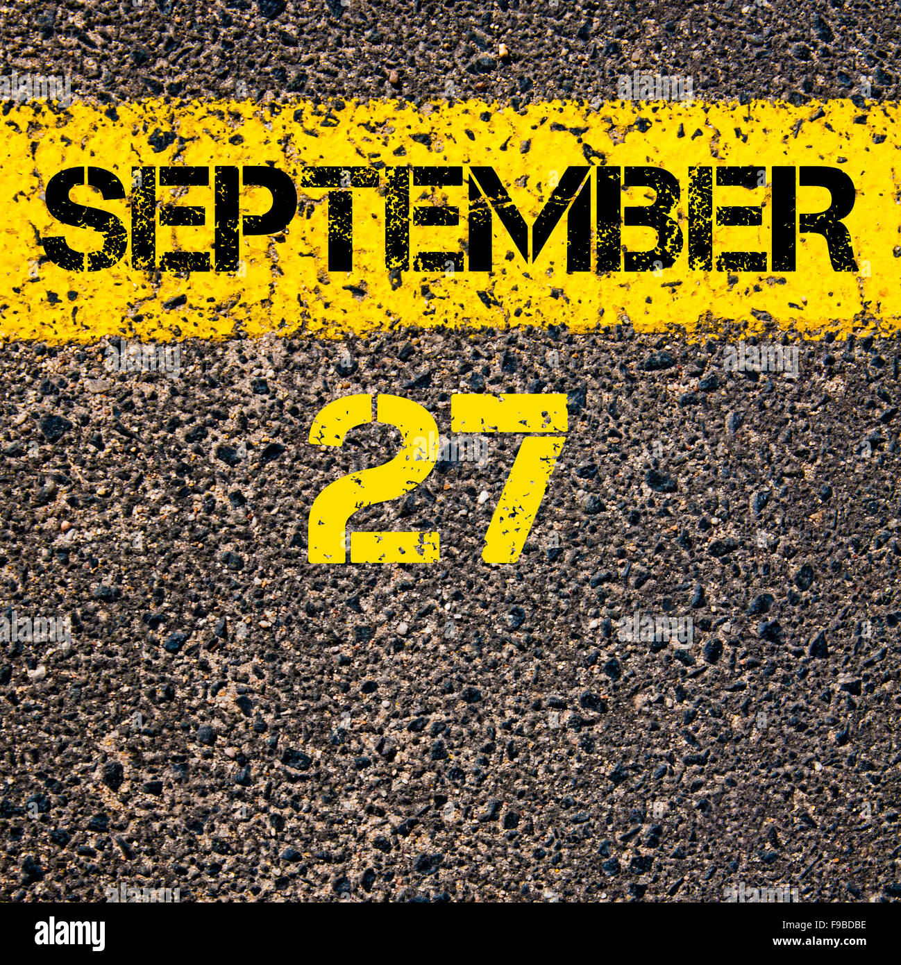 27 September calendar day written over road marking yellow paint line ...