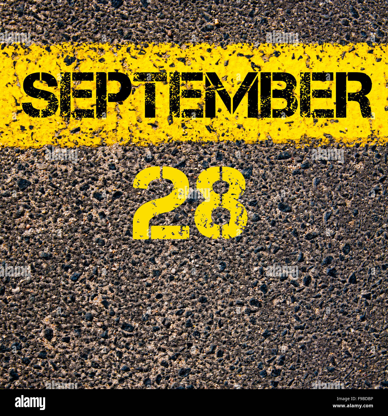 28 September calendar day written over road marking yellow paint line ...