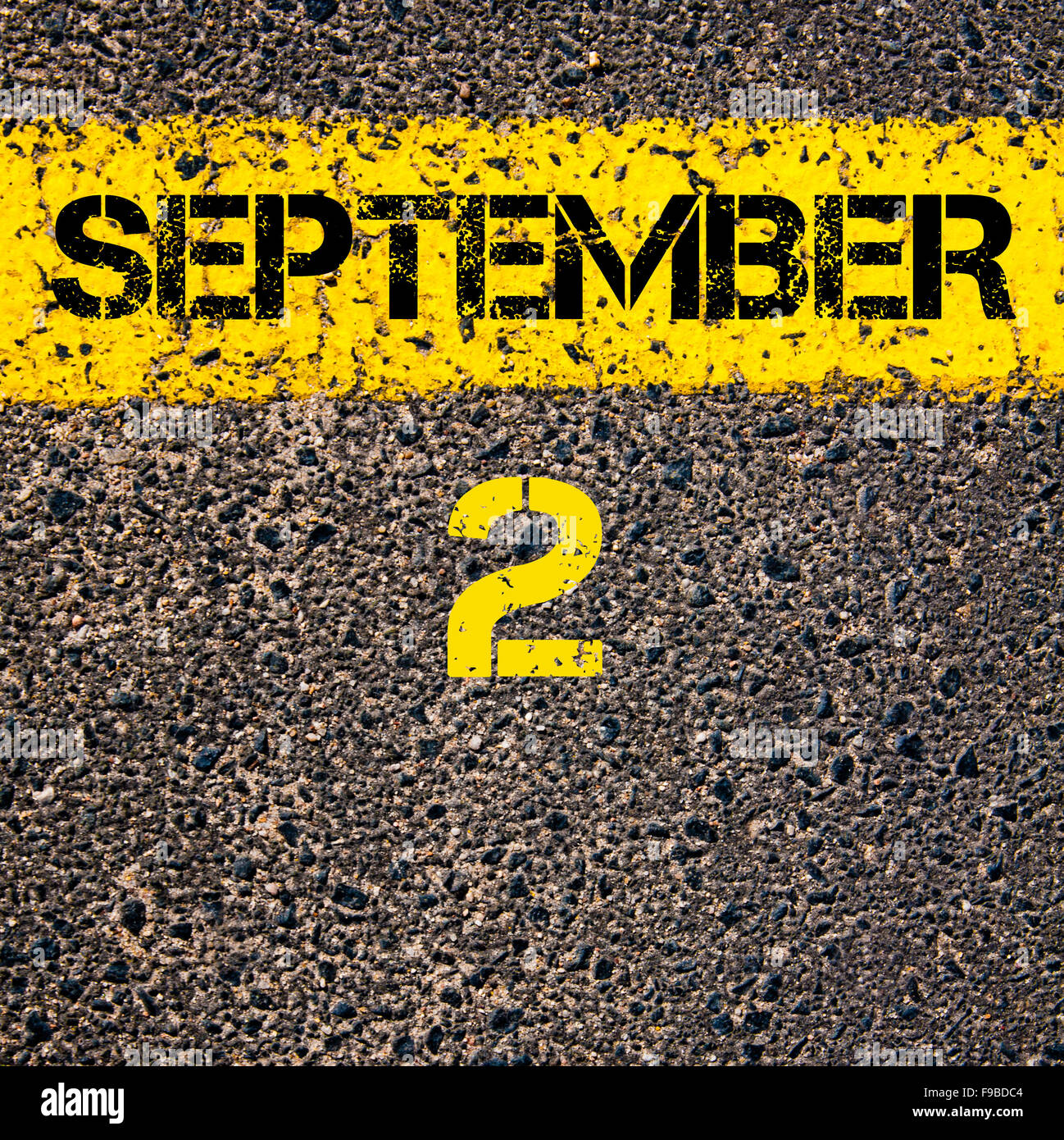 2 September calendar day written over road marking yellow paint line ...