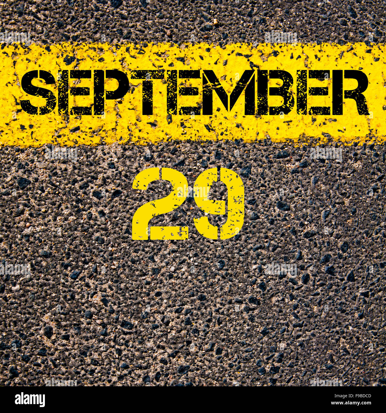 29 September calendar day written over road marking yellow paint line ...
