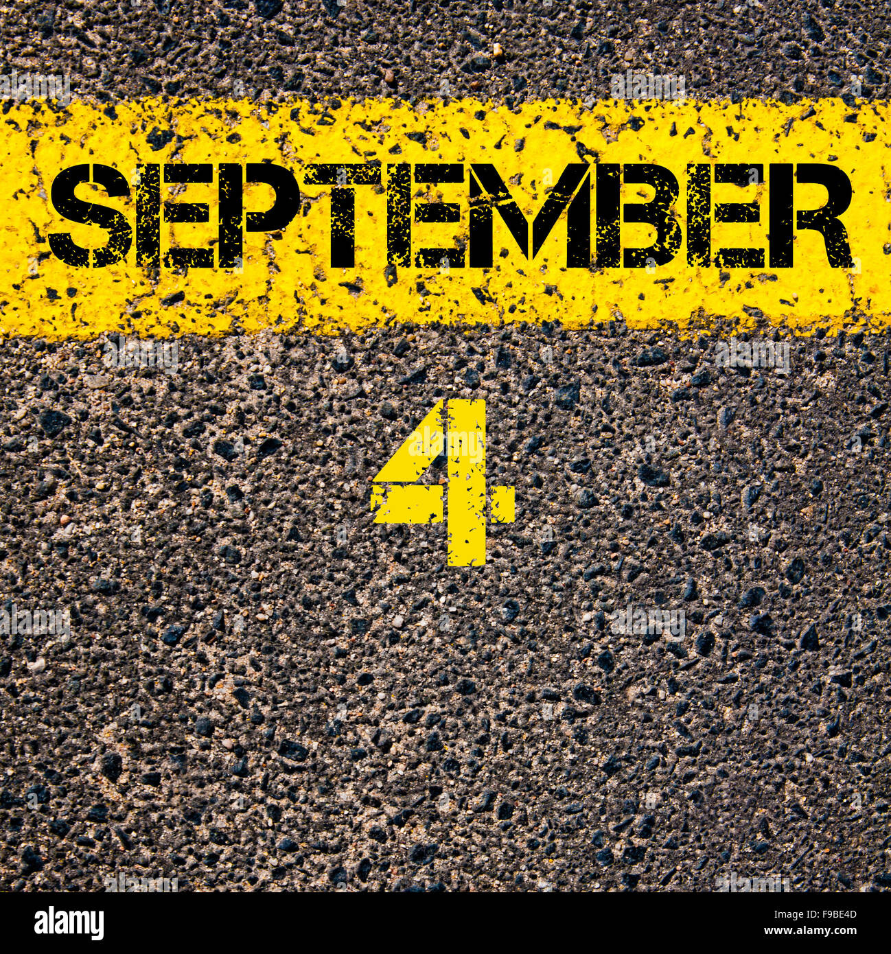 4 September calendar day written over road marking yellow paint line ...