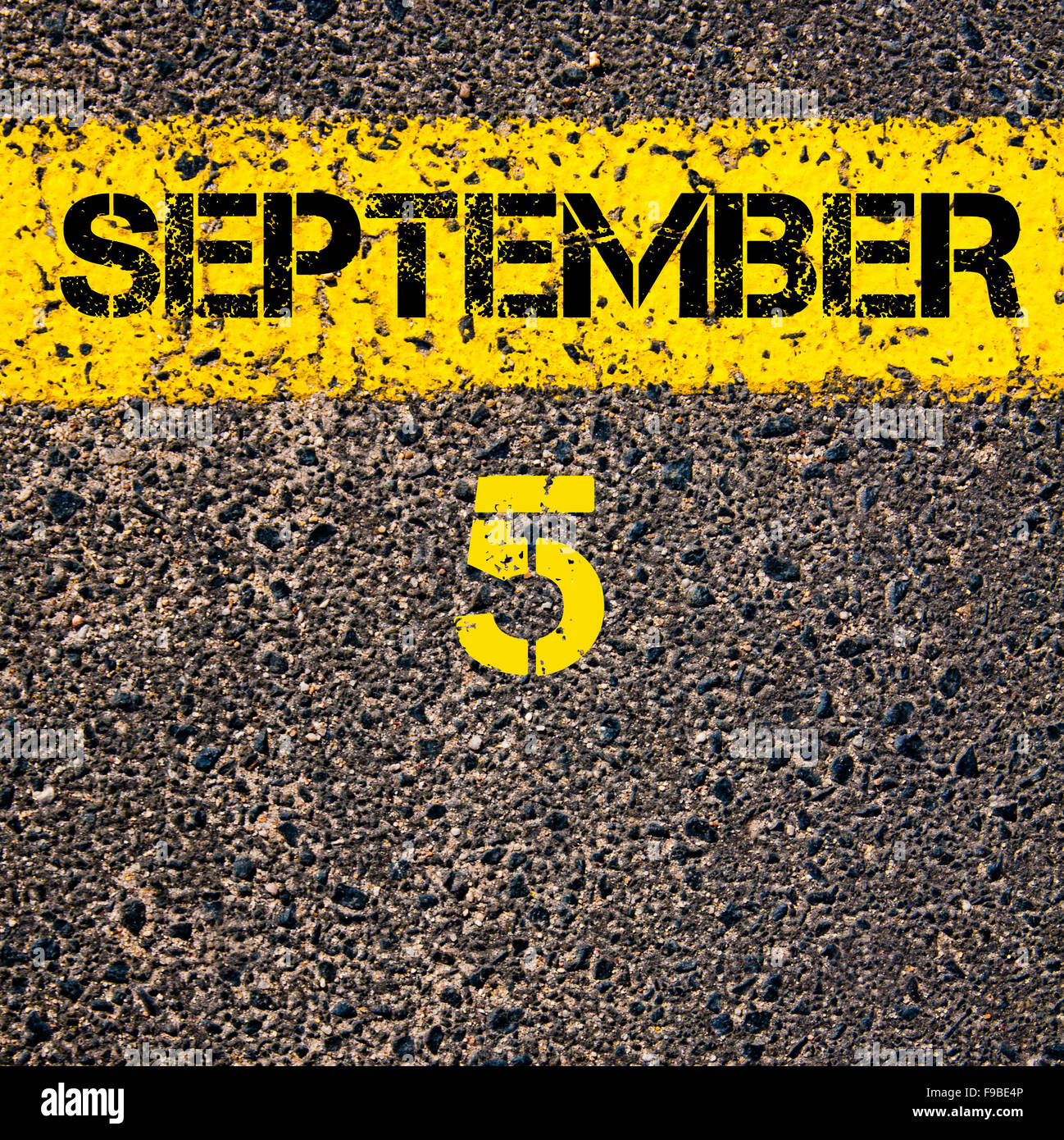 5 September calendar day written over road marking yellow paint line ...