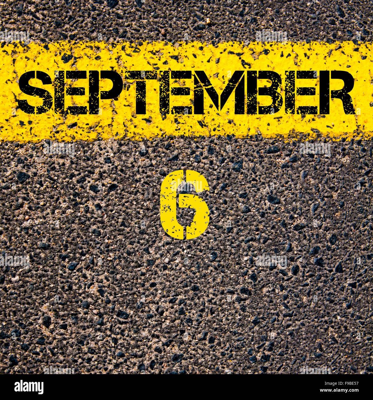 6 September calendar day written over road marking yellow paint line ...