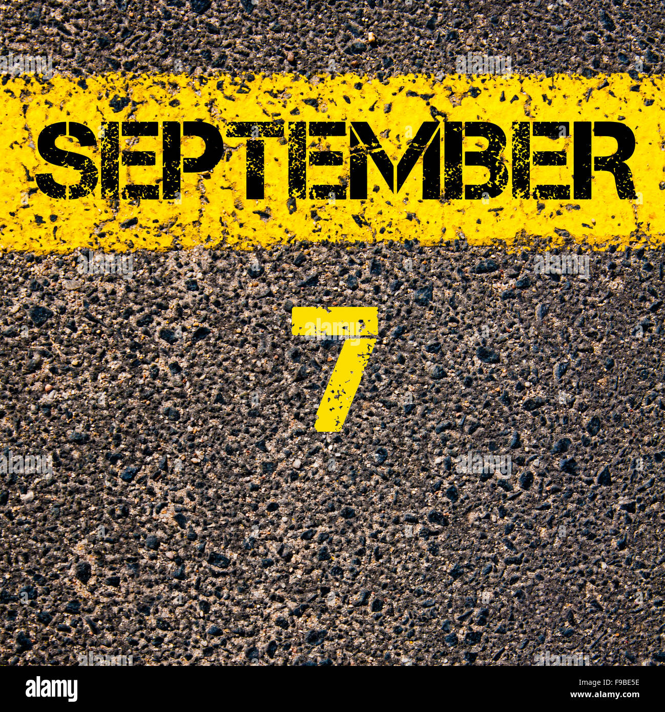 7 September calendar day written over road marking yellow paint line ...