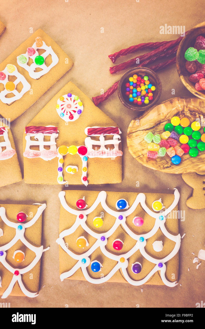 Decorating gingerbread house with royal icing and colorful candies ...