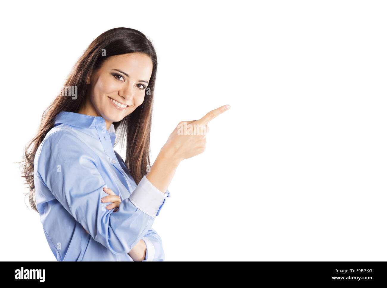 Beautiful young woman pointing to somewhere, isolated over a white ...