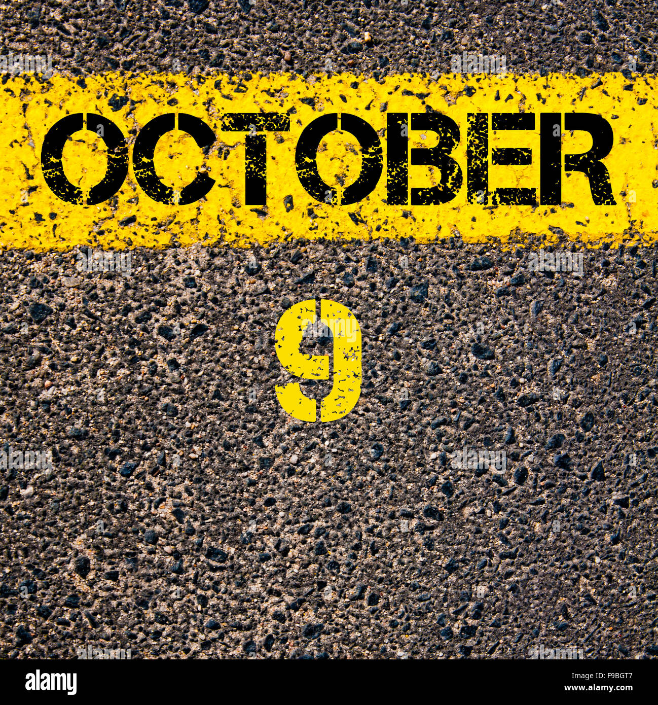 9 October calendar day written over road marking yellow paint line ...