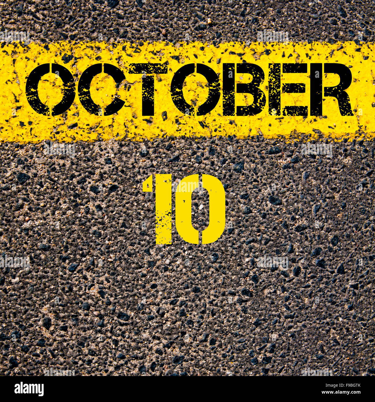 10 October calendar day written over road marking yellow paint line ...