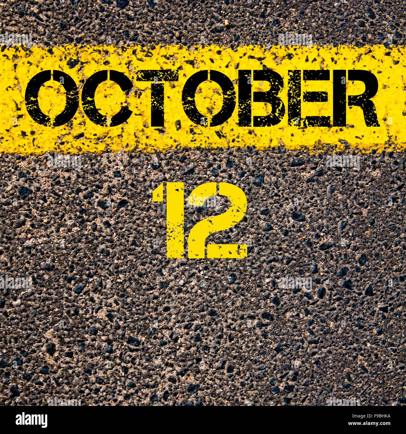 12 October calendar day written over road marking yellow paint line ...