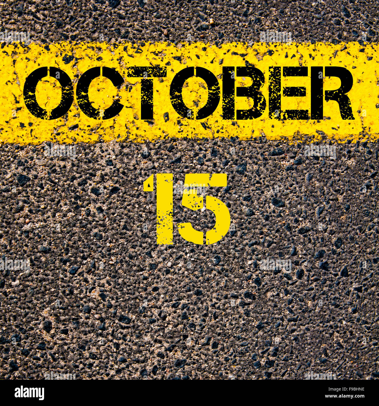 15 October calendar day written over road marking yellow paint line ...