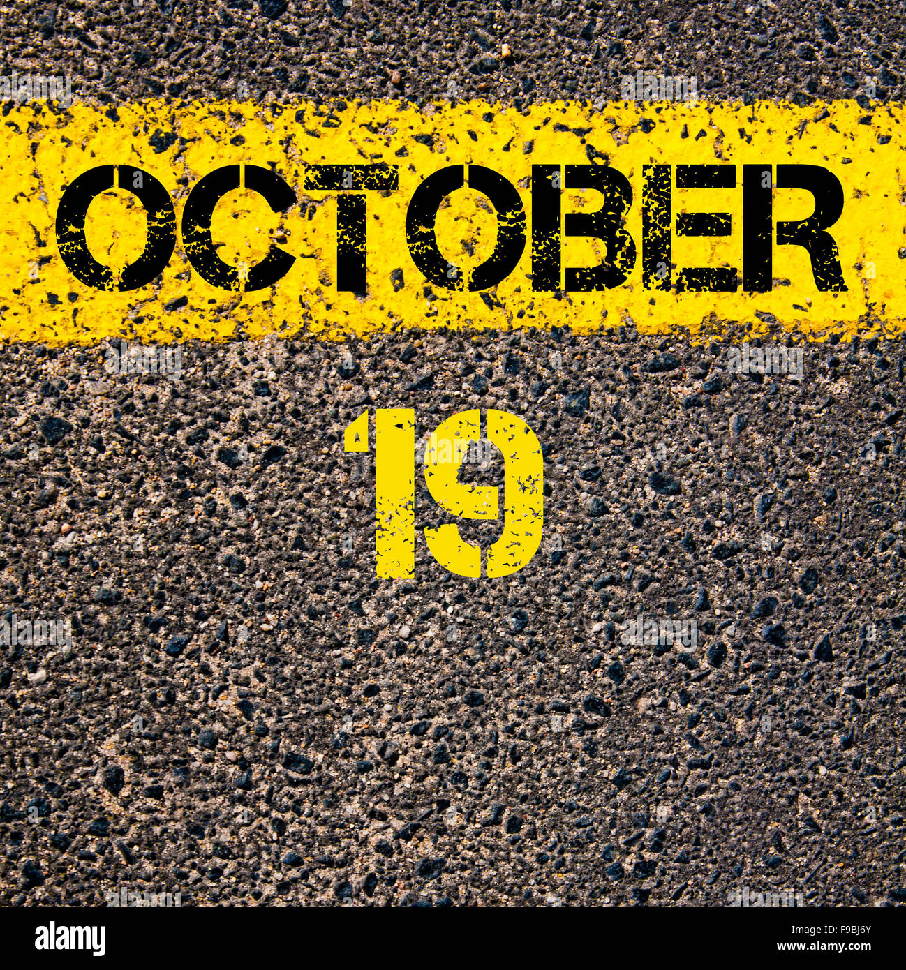 19 October calendar day written over road marking yellow paint line ...