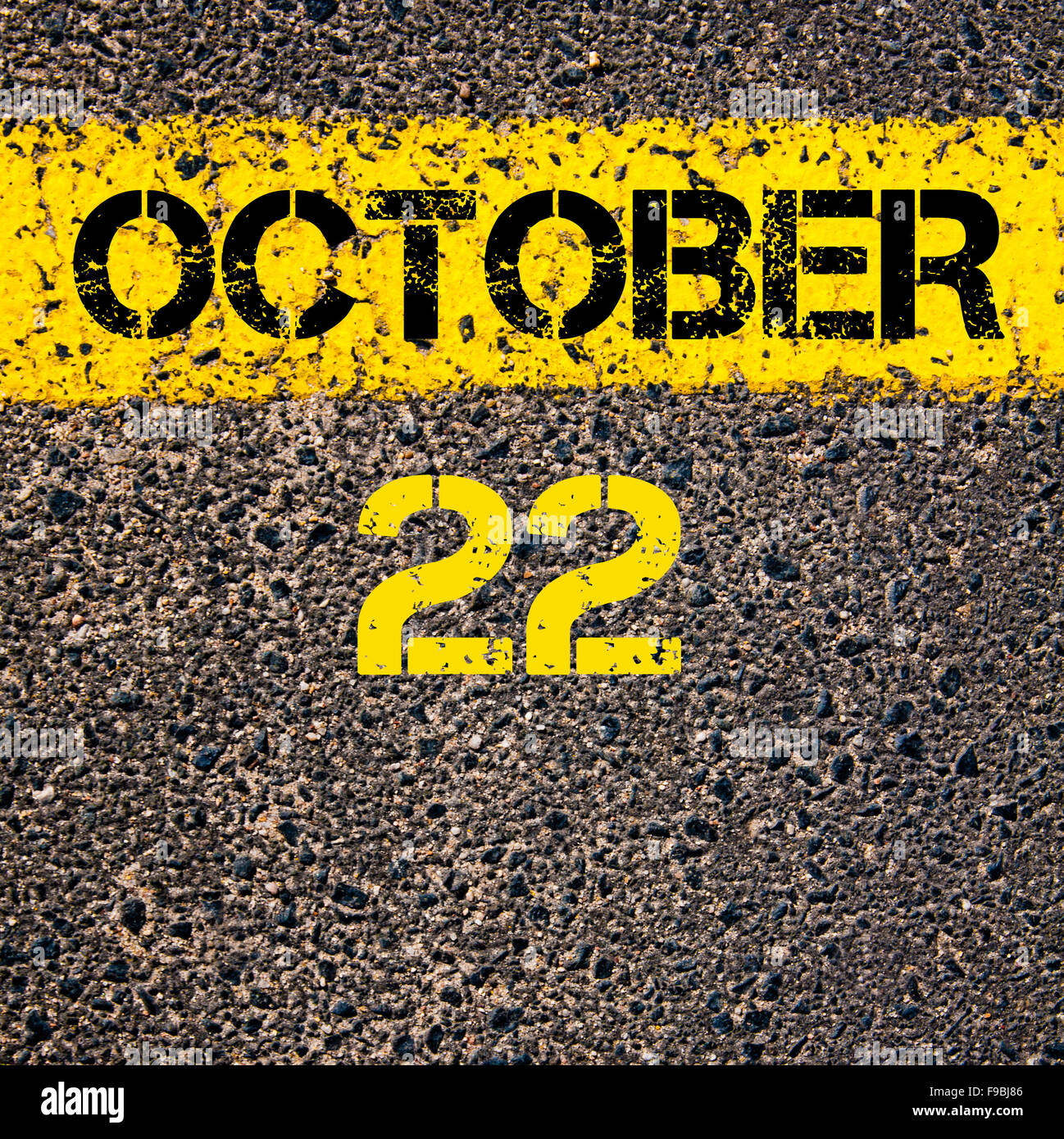 22 October calendar day written over road marking yellow paint line ...