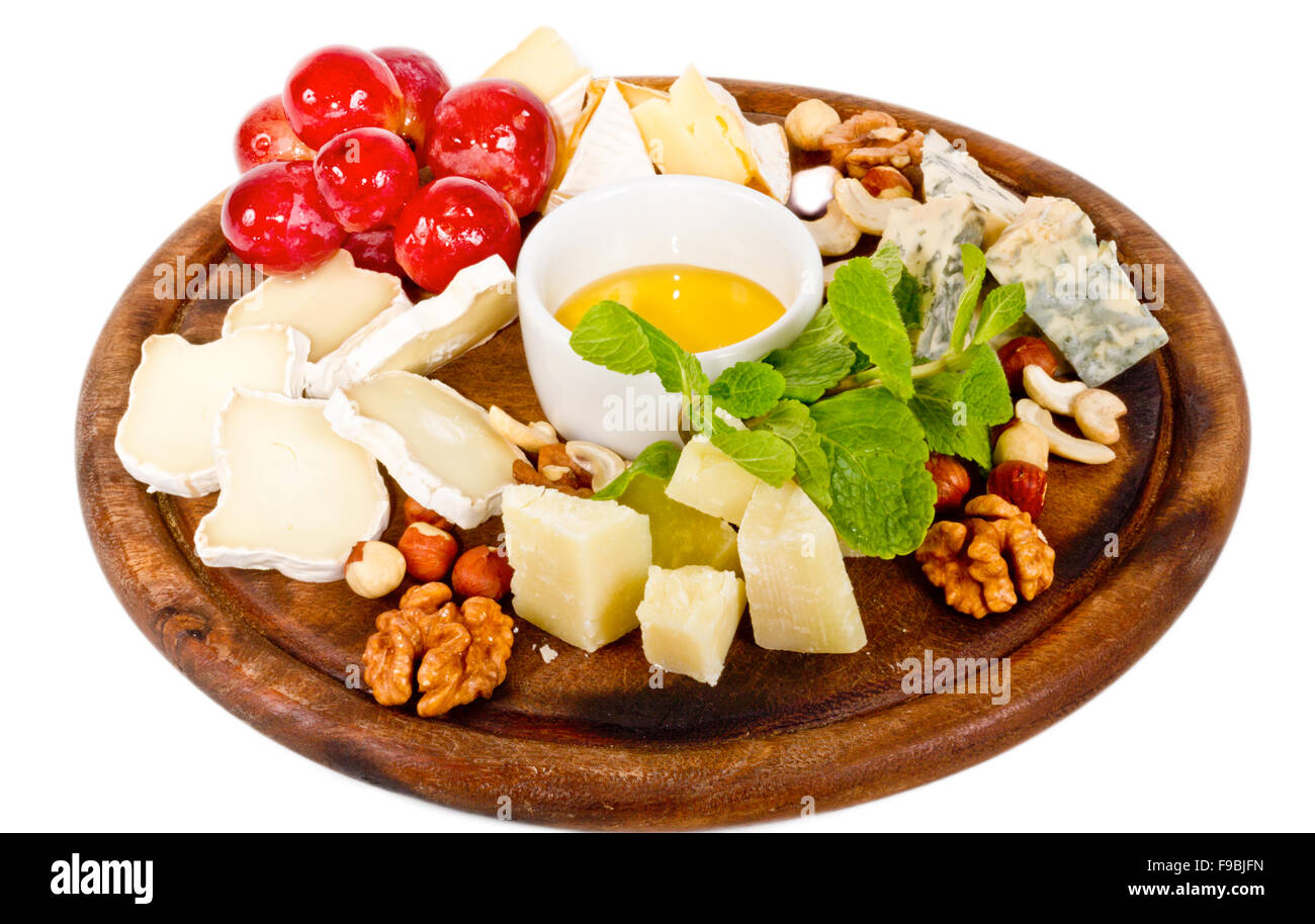 Various types of cheese with honey, nuts and grapes on plate, isolated ...
