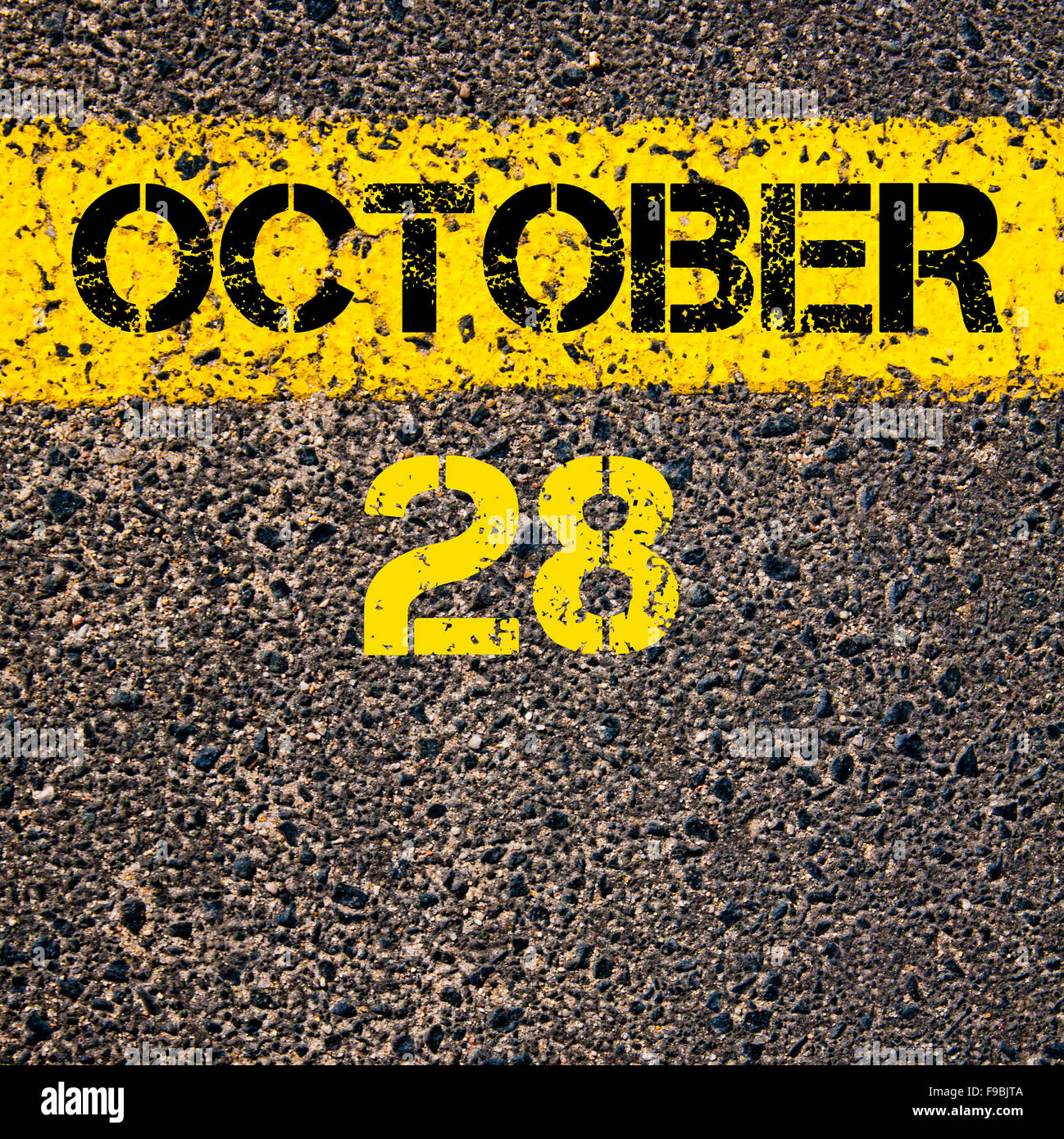 28 October calendar day written over road marking yellow paint line ...