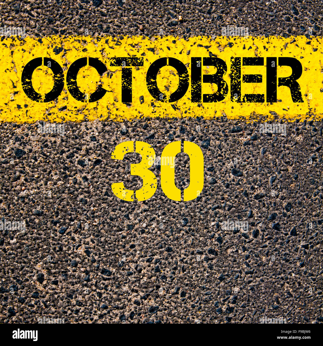 30 October calendar day written over road marking yellow paint line ...
