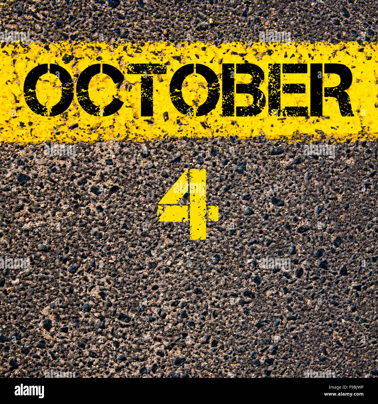 4 October calendar day written over road marking yellow paint line ...