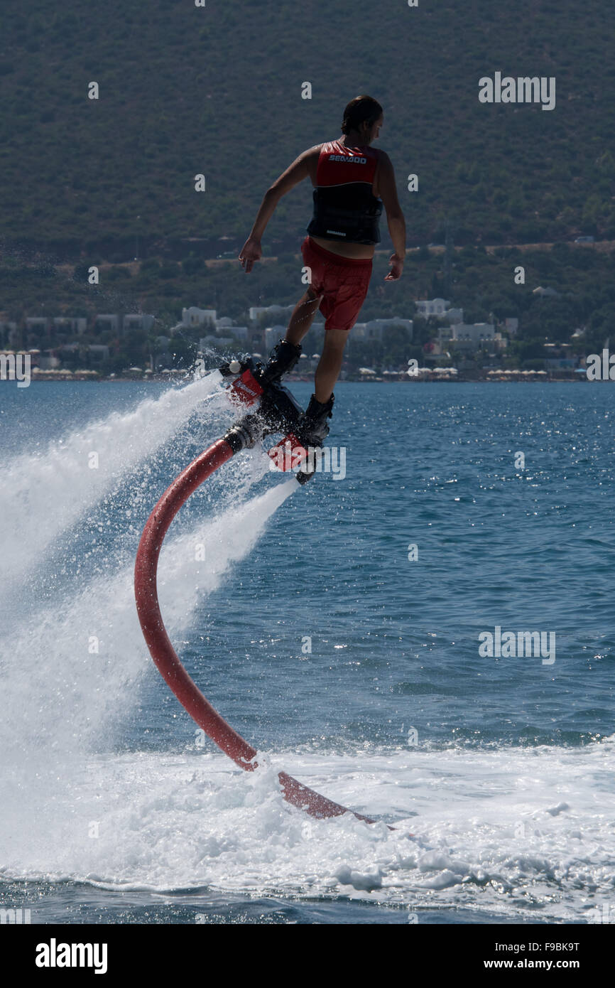 Flyboarder twisting with wooded hills in background Stock Photo - Alamy