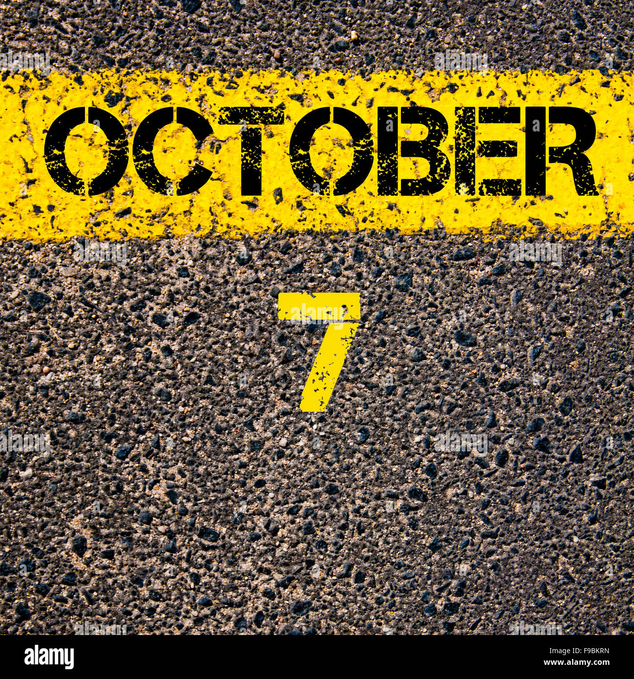 7 October calendar day written over road marking yellow paint line ...