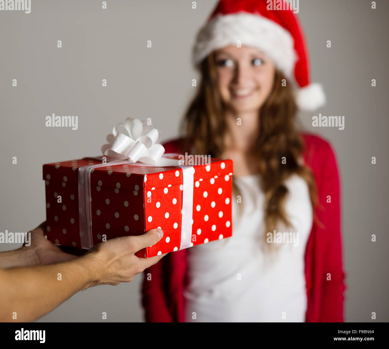 Beautiful smiling woman opening her christmas gift Stock Photo - Alamy