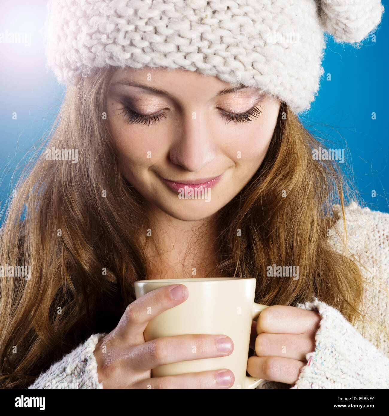 Beautiful woman in warm sweater on blue background Stock Photo - Alamy