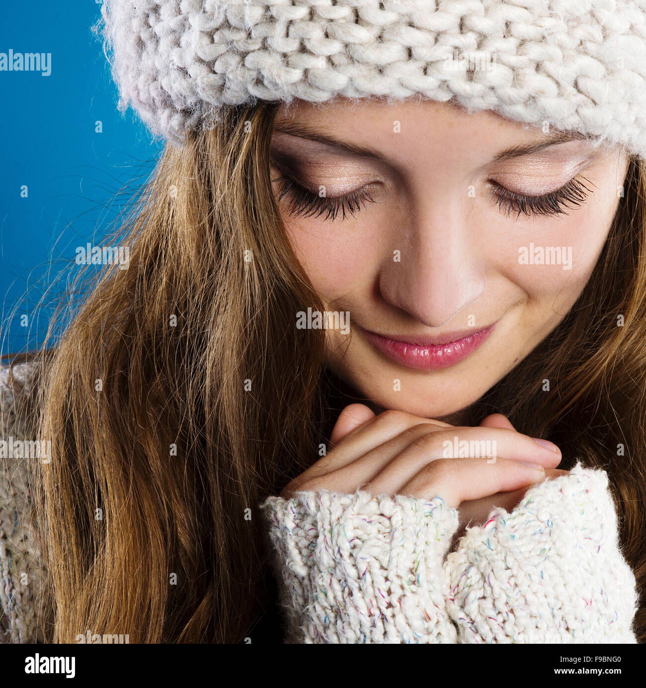 Beautiful woman in warm sweater on blue background Stock Photo - Alamy
