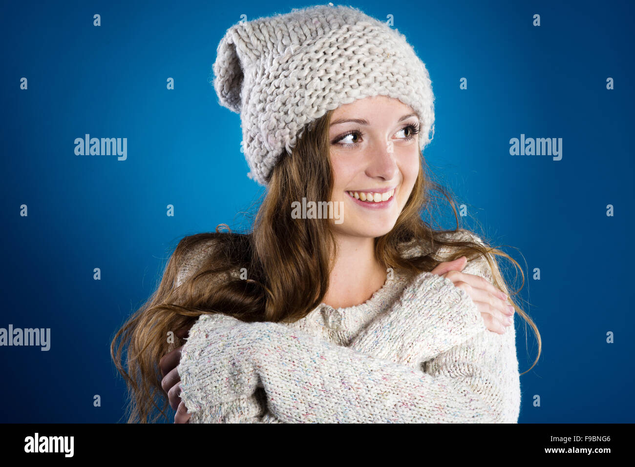 Beautiful woman in warm sweater on blue background Stock Photo - Alamy