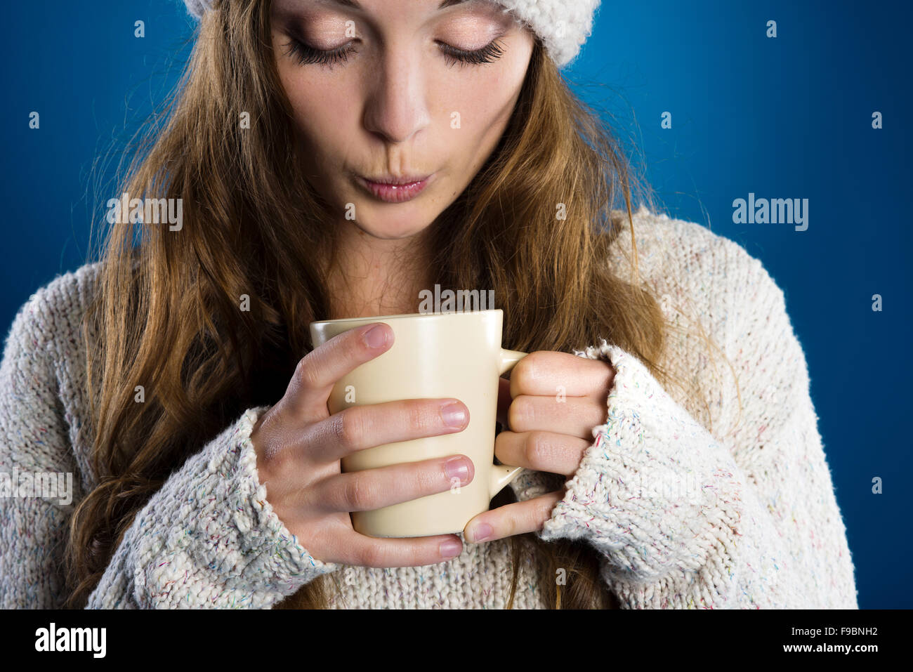 Beautiful woman in warm sweater on blue background Stock Photo - Alamy