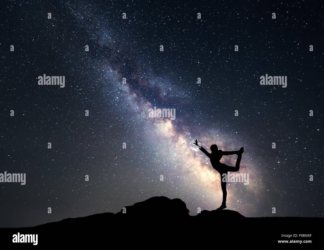 Milky Way. Night sky with stars and silhouette of a woman practicing ...