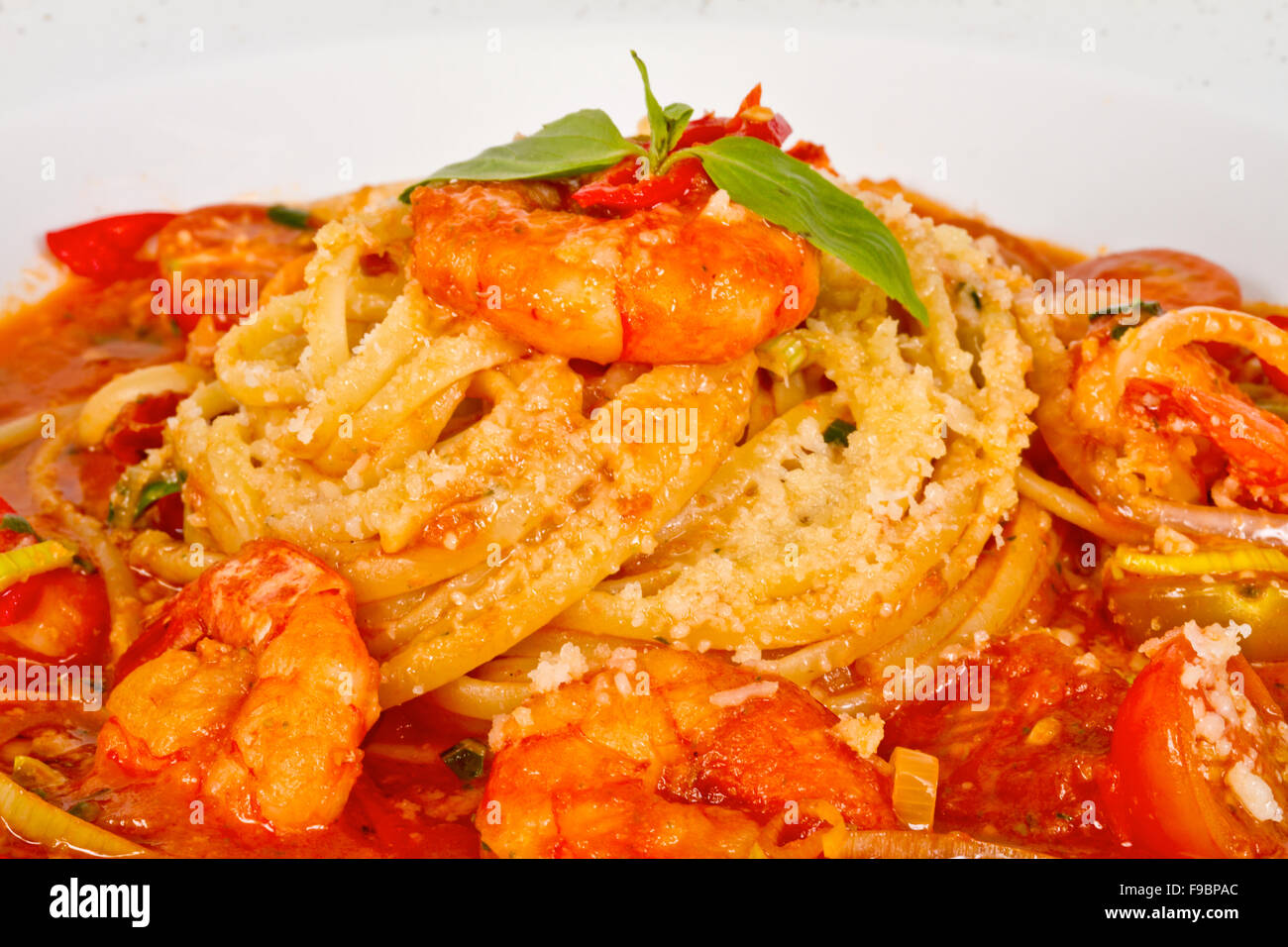 A plate of linguini with sauteed shrimp, tomato, chili and olive oil ...