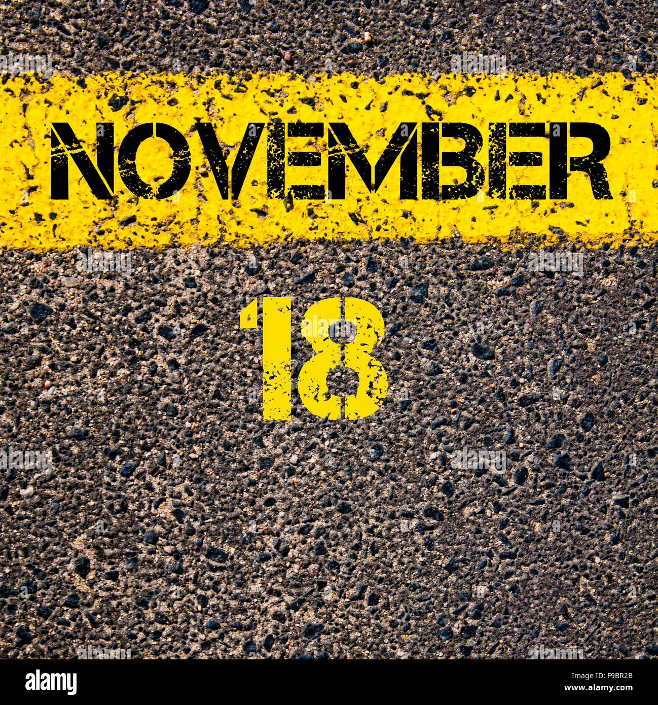 18 November calendar day written over road marking yellow paint line ...