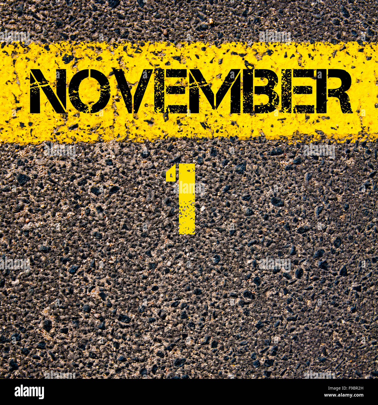 1 November calendar day written over road marking yellow paint line ...