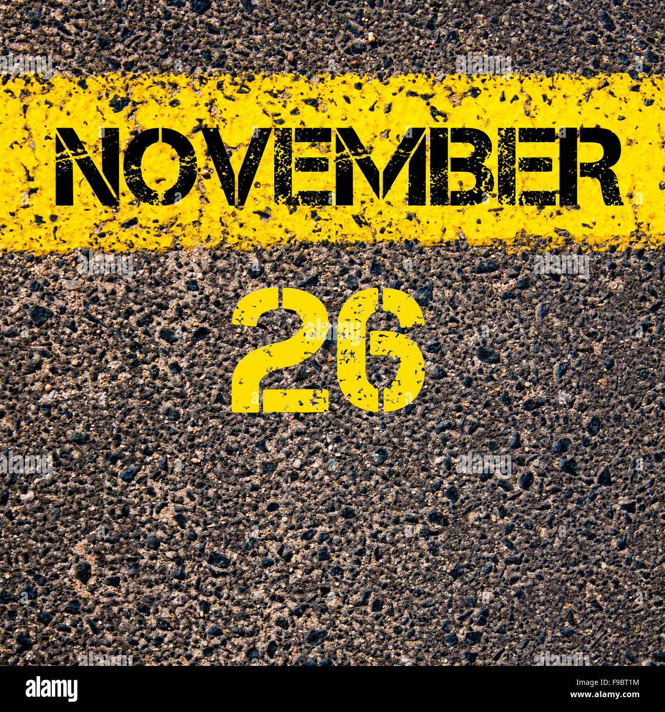 26 November calendar day written over road marking yellow paint line ...