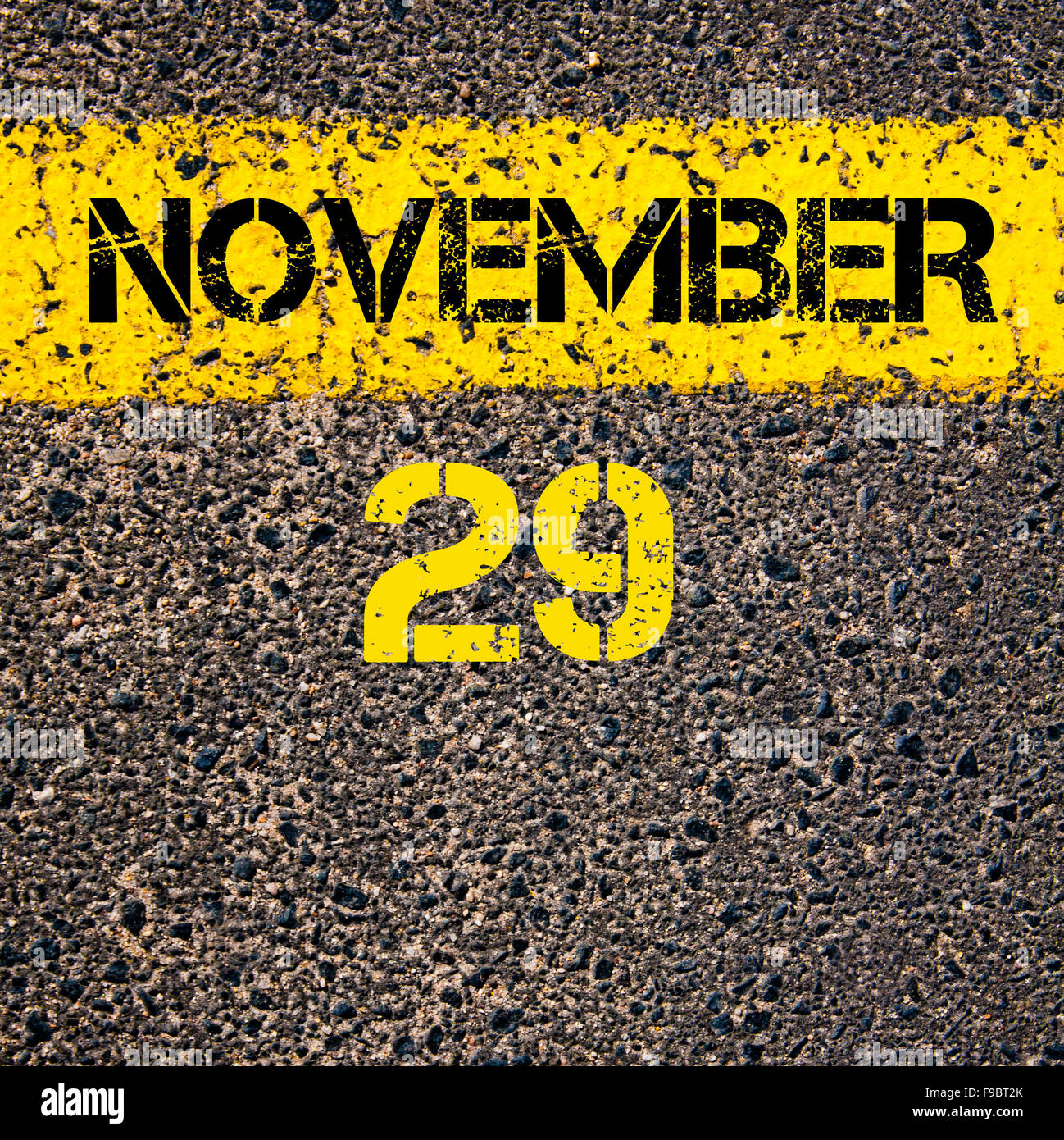 29 November calendar day written over road marking yellow paint line ...