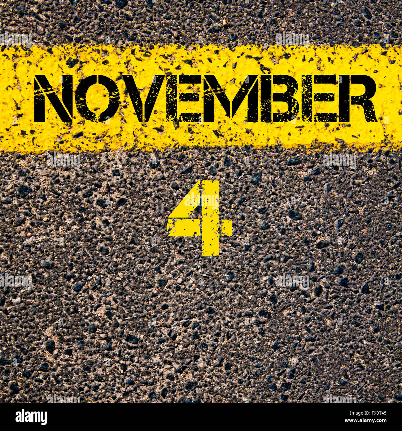 4 November calendar day written over road marking yellow paint line ...