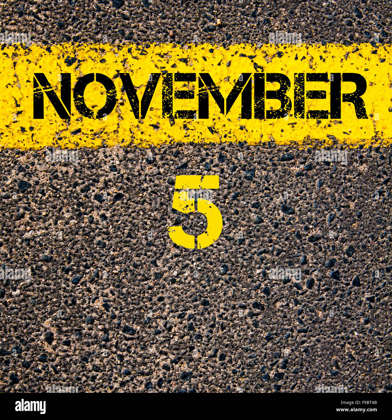5 November calendar day written over road marking yellow paint line ...